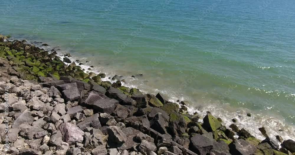 Aerial view of a coastal protection barrier in the form of large rocks ...