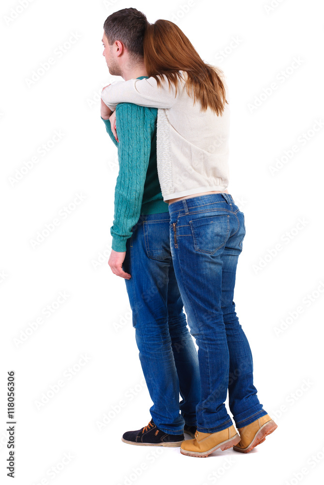 Back view of young embracing couple (man and woman) hug and look into ...