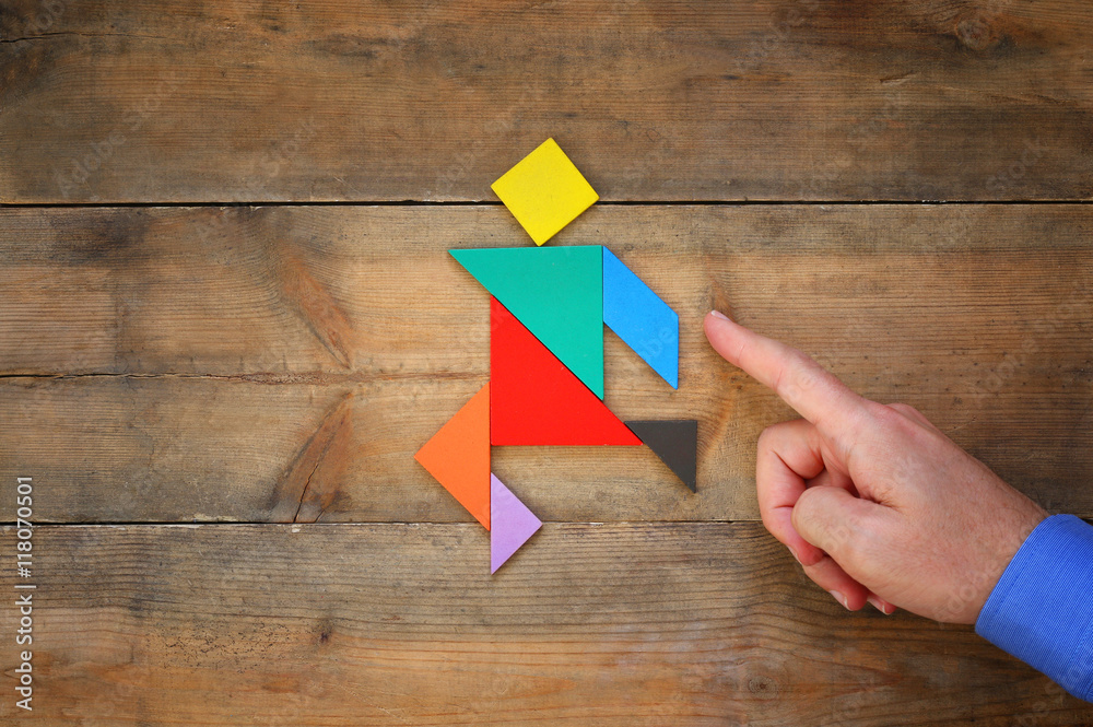 man's hand pointing at running man made from tangram puzzle Stock Photo ...