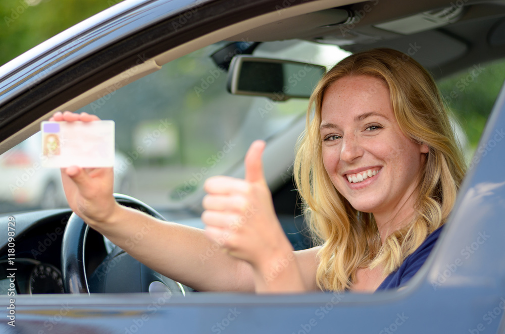 Young blond woman showing off her drivers license Stock Photo | Adobe Stock