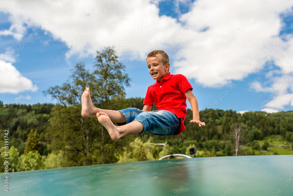 Young boy jumping on trampoline Stock Photo | Adobe Stock