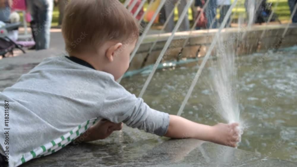 Little boy playing with water jets in the fountain. Kid having outdoor ...