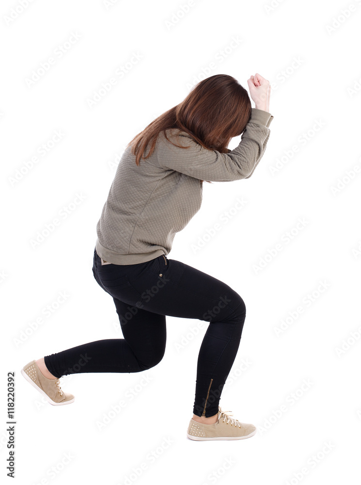 back view of standing young beautiful woman in jeans. girl watching ...