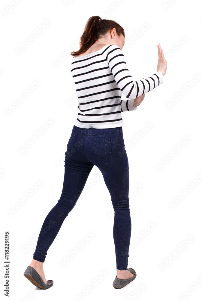back view of woman pushes wall. Isolated over white background. Rear ...
