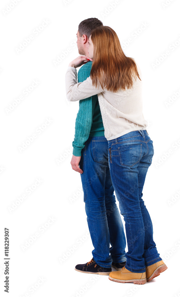 Back view of young embracing couple (man and woman) hug and look into ...