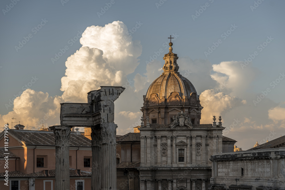 Roman buildings and ruins, in Rome, set against a deep blue sky with ...