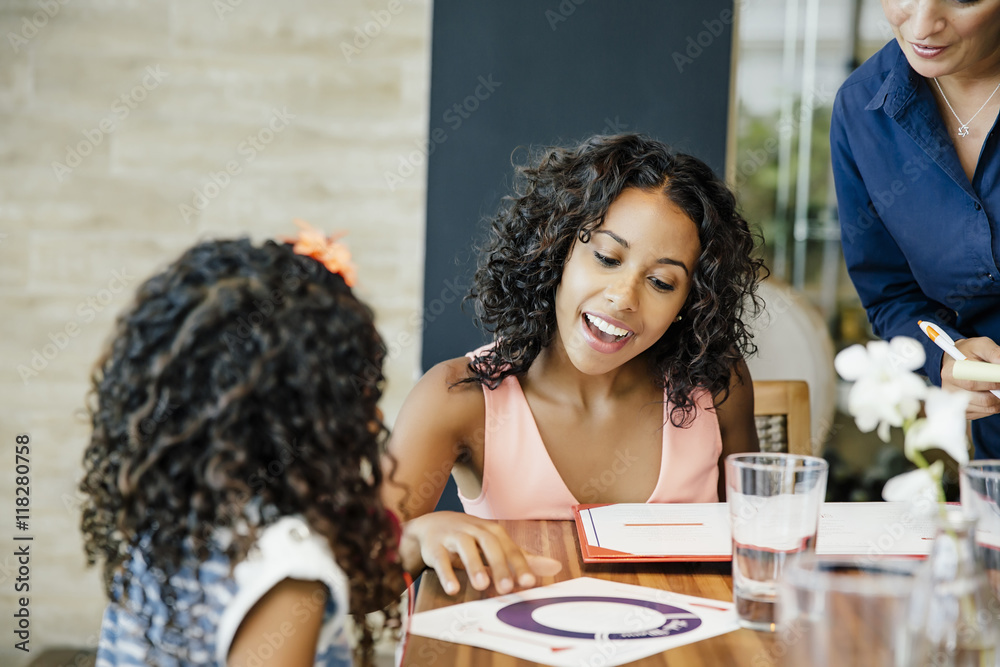 Mother and daughter reading menu restaurant table Stock Photo | Adobe Stock