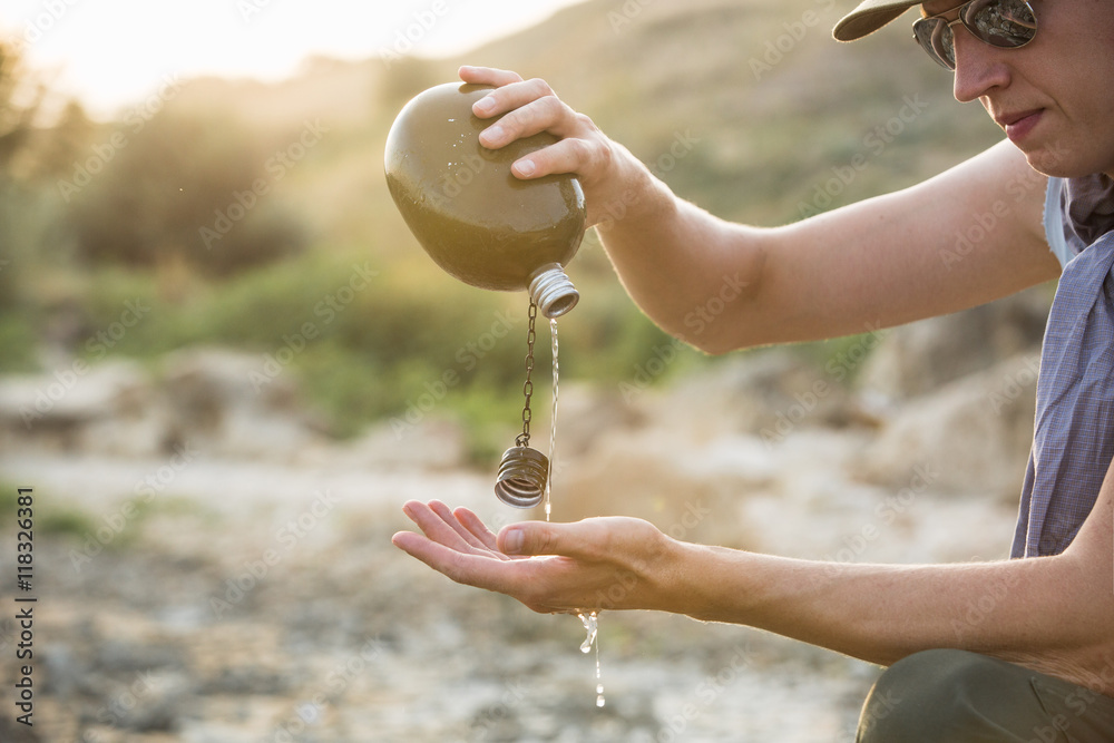 man in the desert, search for water, military flask with water ...