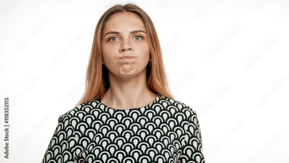 Nervous angry young beautiful blonde girl over white background. Slow ...