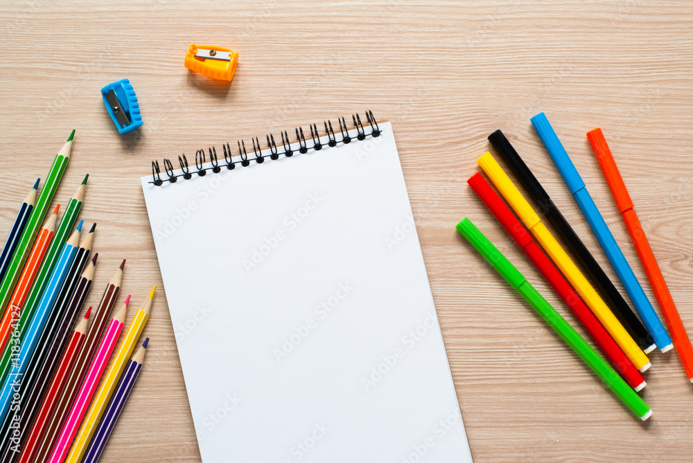 Pencils, crayons and notebook on a desk. Stock Photo | Adobe Stock