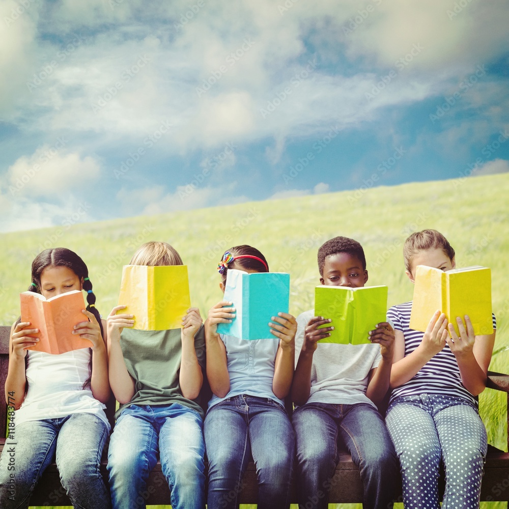 Composite image of children reading books at park Stock Photo | Adobe Stock