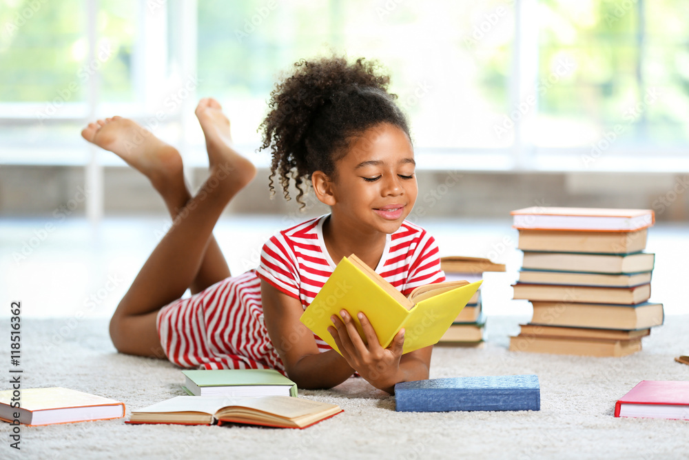 Cute girl reading book at home Stock Photo | Adobe Stock