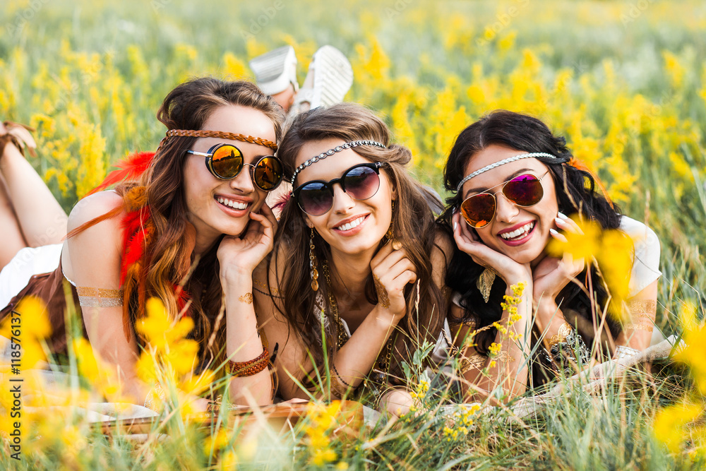 Three cute hippie girl lying on the grass among the wildflowers, best ...