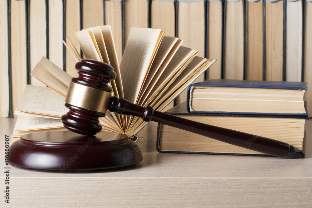 Law concept - Book with wooden judges gavel on table in a courtroom or ...