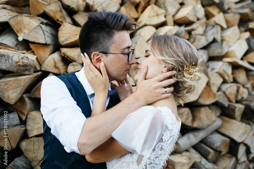 Pretty Couple Hold Each Other Faces While Posing Before The Wood Stock