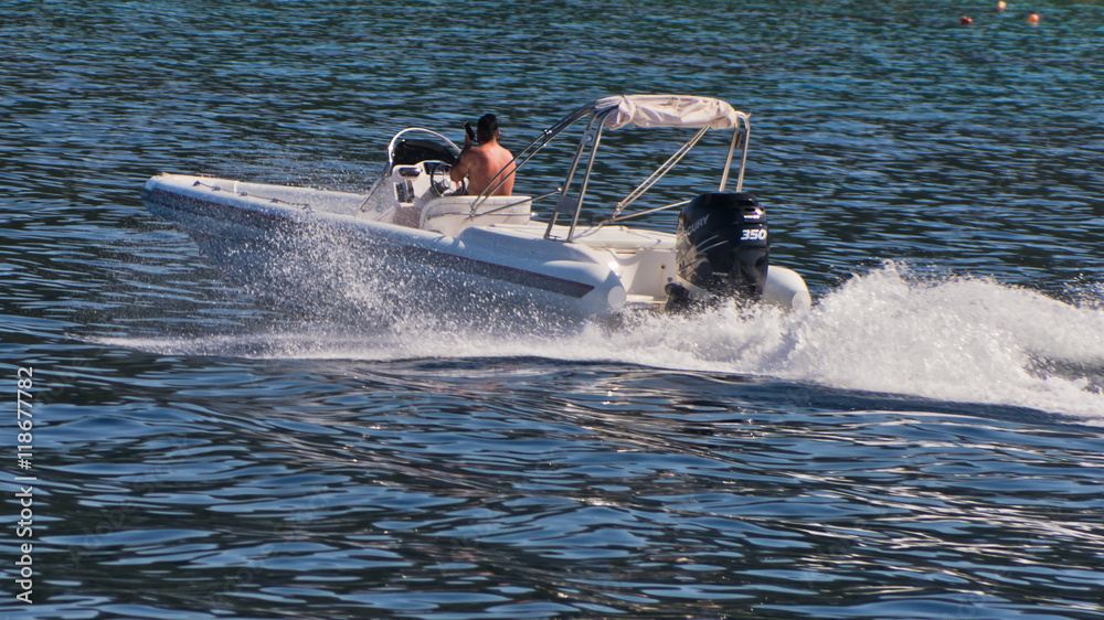White speed boat at sea in front of a sandy beach, Sithonia, Greece ...