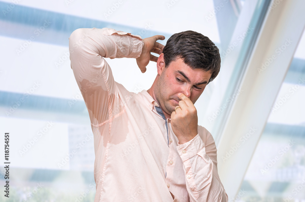 Man with sweating under armpit pinches nose with fingers Stock-Foto ...