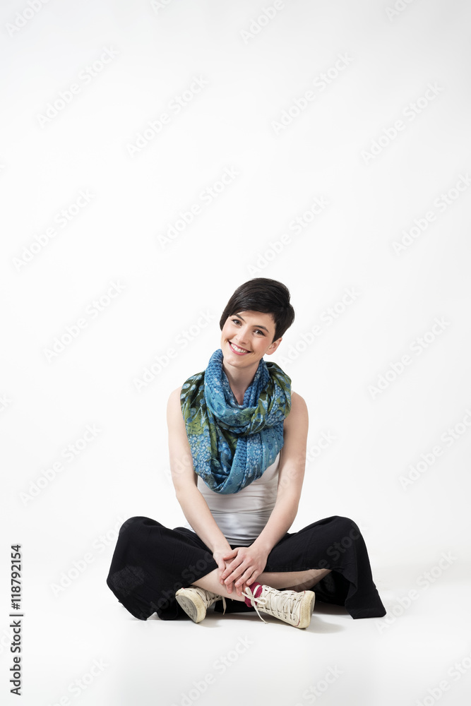 Cute pretty woman sitting with crossed legs and smiling at camera over ...