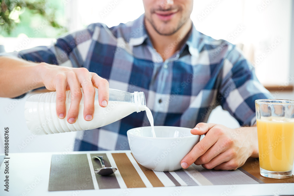 Man pouring milk into bowl for breakfast on the kitchen Stock Photo ...