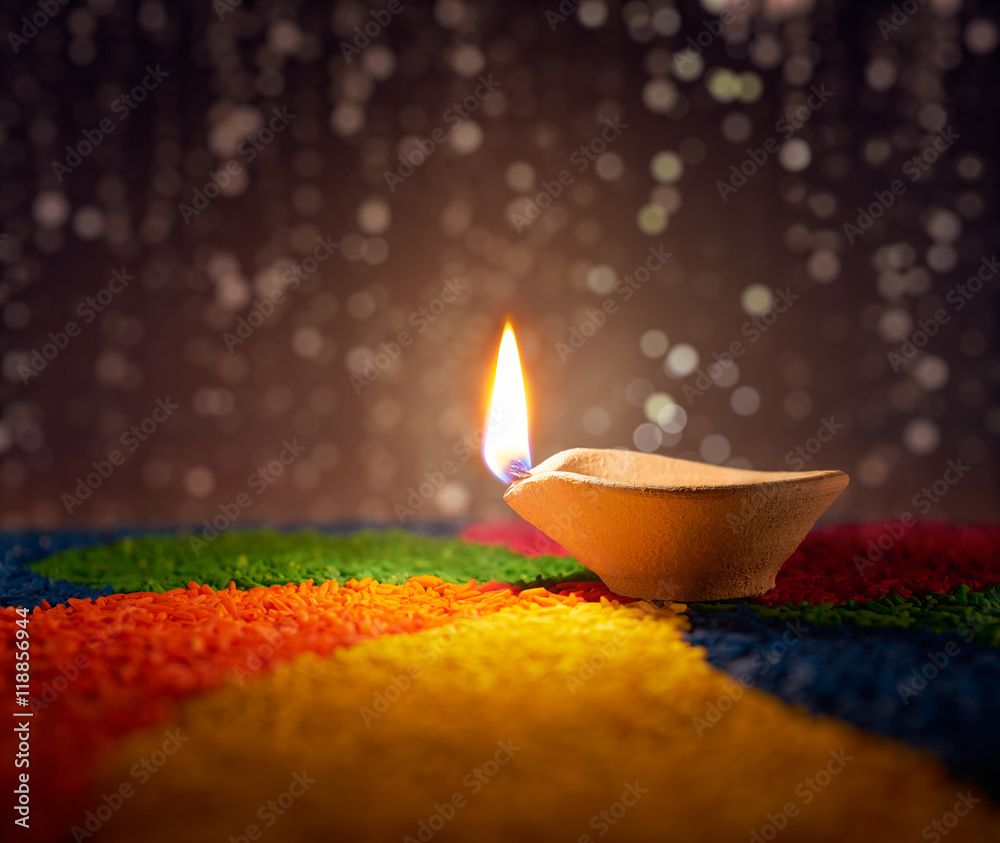 Traditional diya lamp lit on colorful rangoli Stock Photo | Adobe Stock