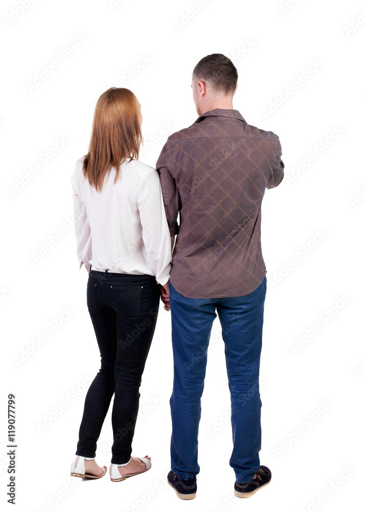 Back view of young embracing couple (man and woman) hug and look into ...