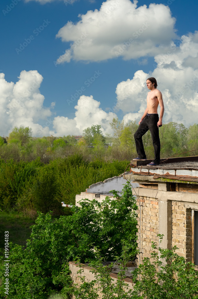 Brave adventures man standing on roof edge of old building Stock Photo ...