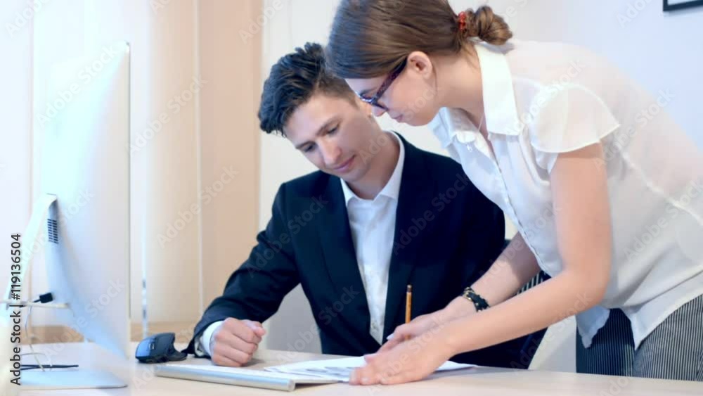 Secretary bringing documents to male boss. A man checks the information ...