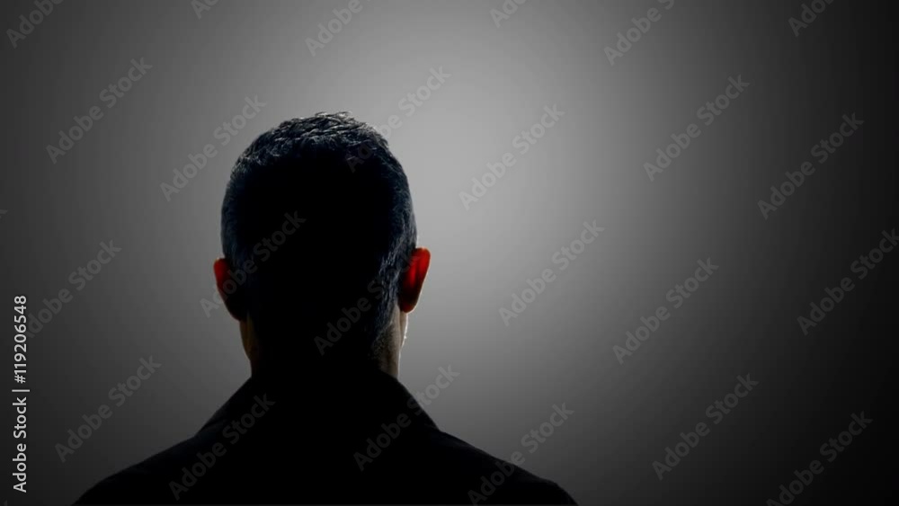 witness criminal being interviewed in a dark room silhouette back view ...
