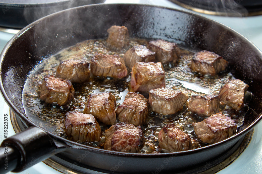 Frying beef bottom round roast cubes in cast iron skillet , meat ...