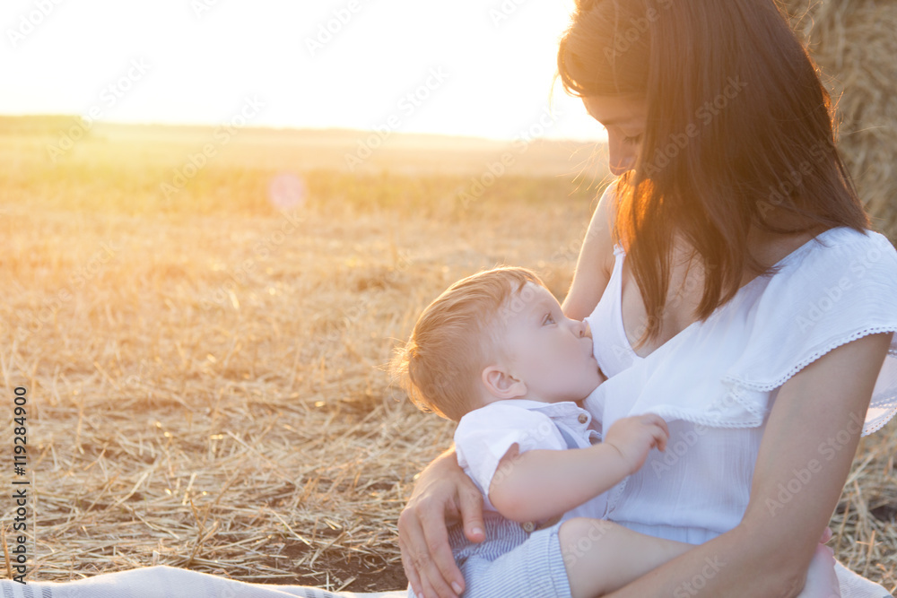 Beautiful happy mother breastfeeding her baby boy outdoor. Mother ...
