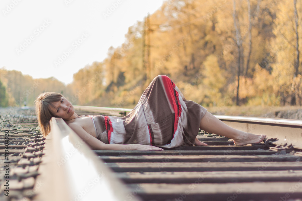 Beautiful girl laying on railroad track. Stock Photo | Adobe Stock