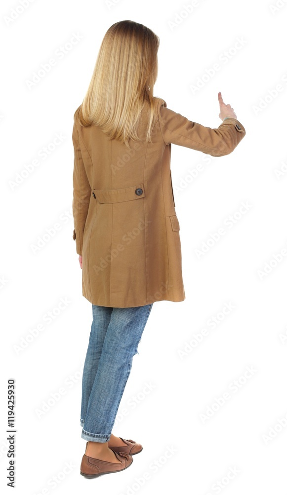 Back view of pointing young women in parka. blonde in a brown cloak ...