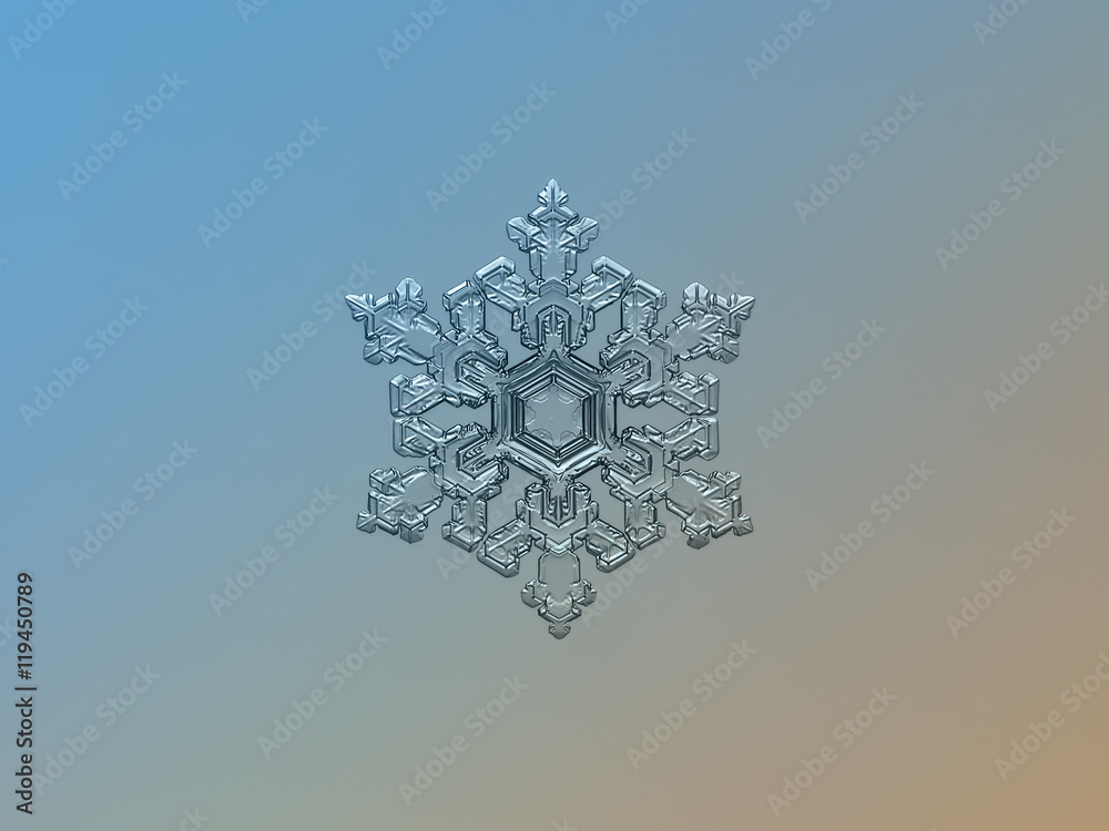 Real snowflake on bright blue-brown gradient background. This is macro ...