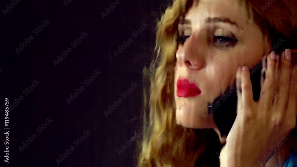 Girl talking on phone and crying. Girl is crying behind window with ...