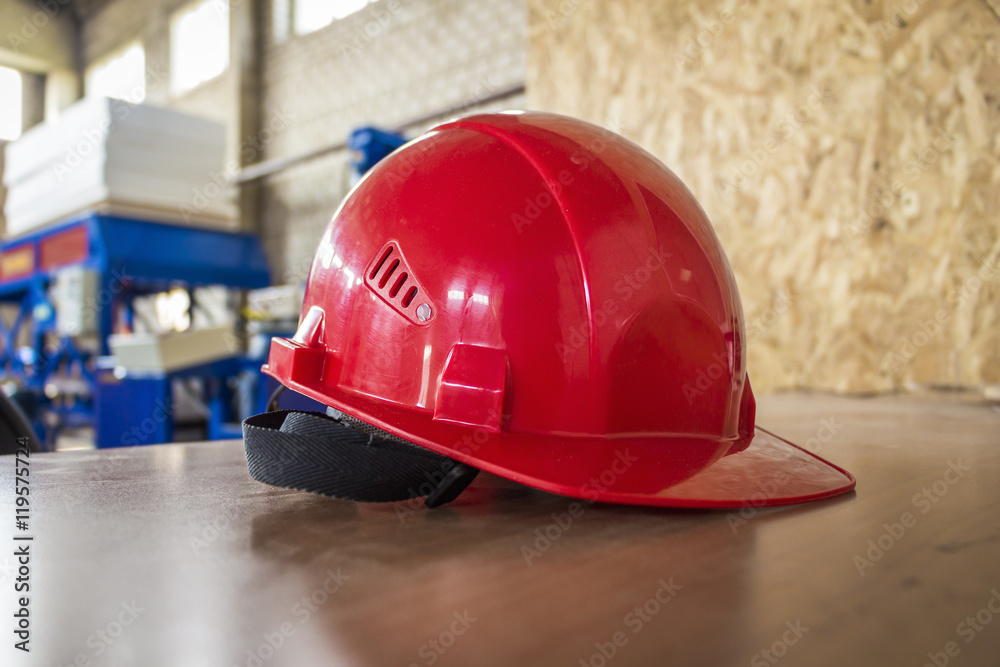 Red hard hat on a table. Stock Photo | Adobe Stock