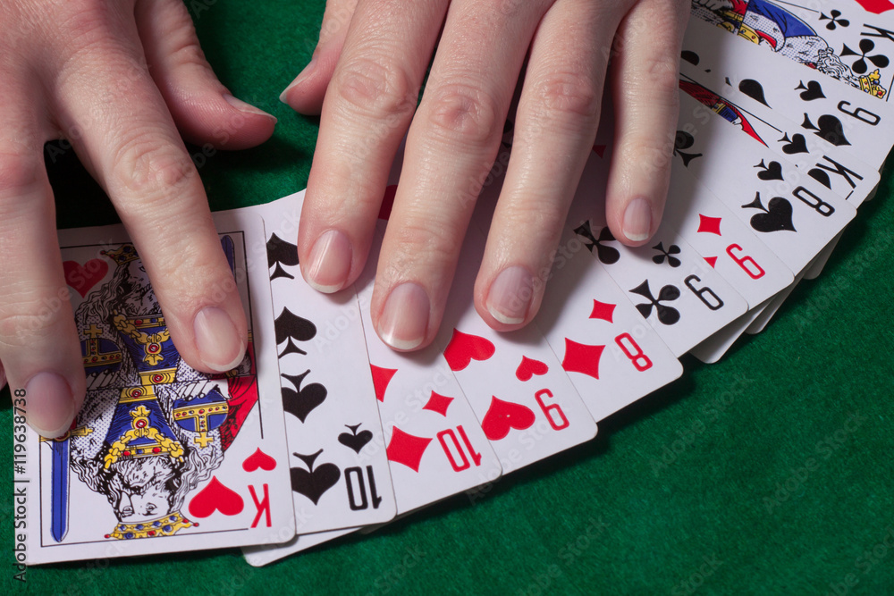 hand lays out a deck of playing cards on a table Stock Photo | Adobe Stock