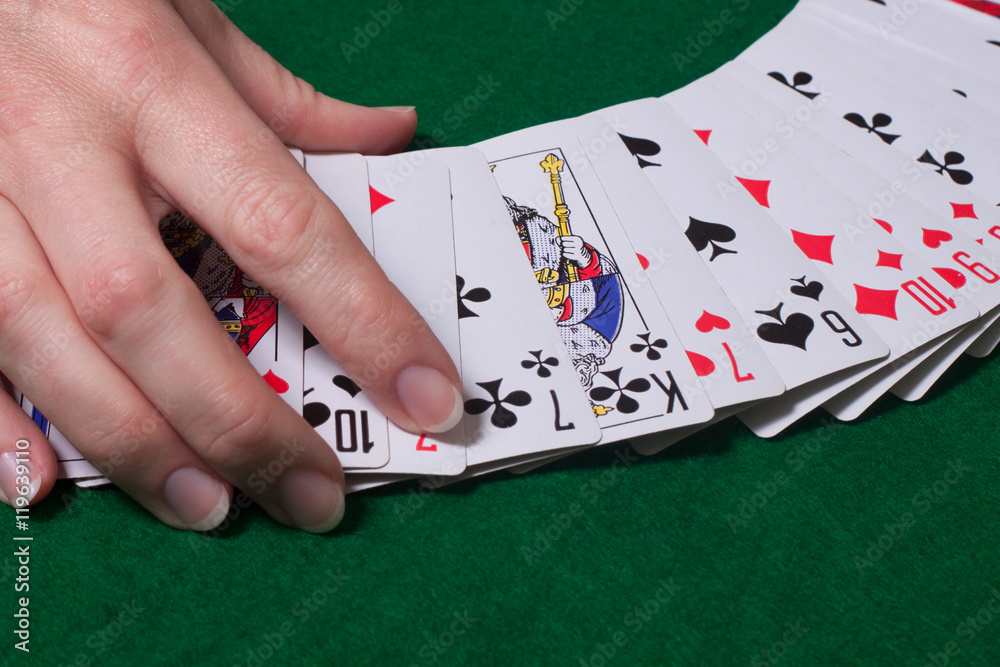 hand lays out a deck of playing cards on a table Stock Photo | Adobe Stock
