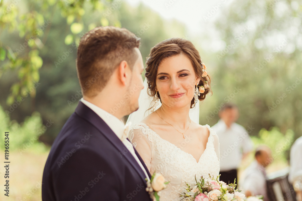 Joyful bride looks at groom with love during the ceremony outsid Stock ...