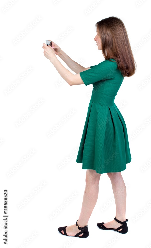 back view of standing young beautiful woman using a mobile phone. girl ...
