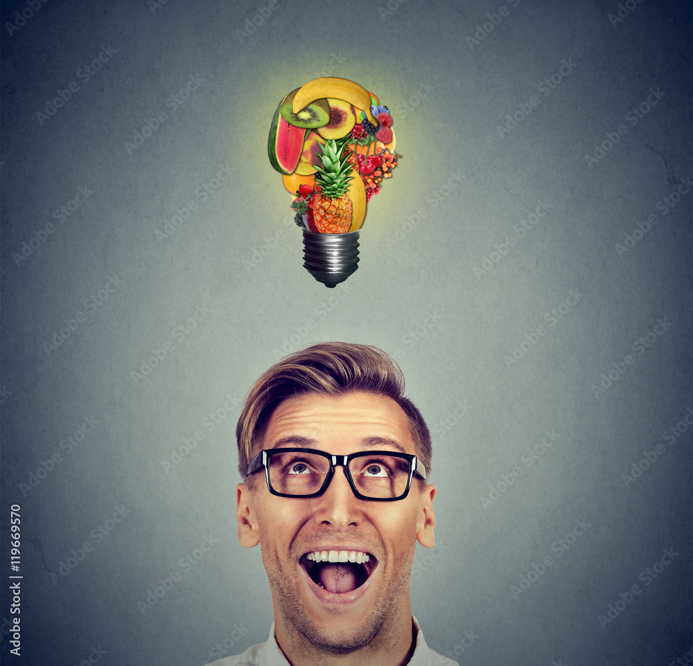 Eating healthy. Man looking up light bulb made of fruits Stock Photo ...