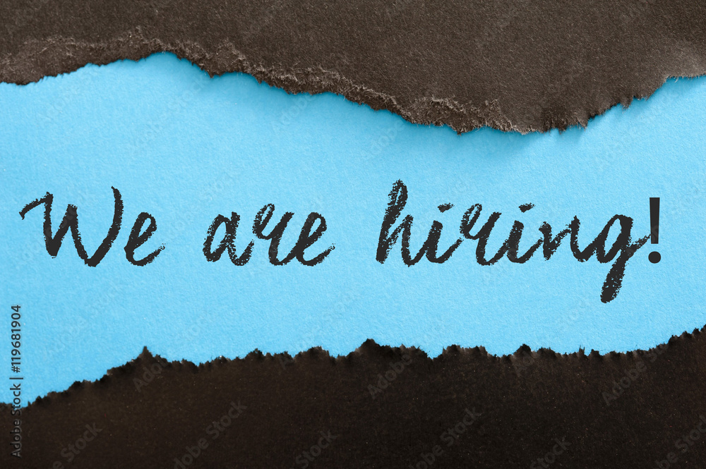 torn blue and black paper background. Phrase we are hiring on the torn ...