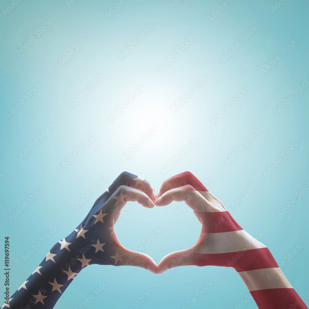 American flag pattern on people hands in heart shaped form against ...