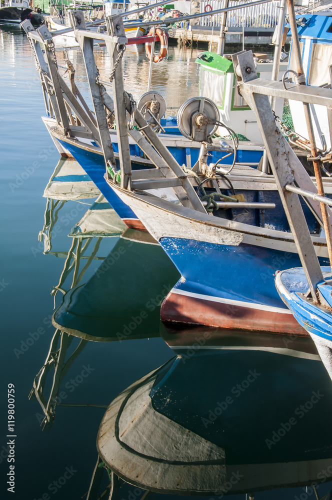 Proas de barcos pesqueros y sus reflejos en el agua del puerto Stock ...