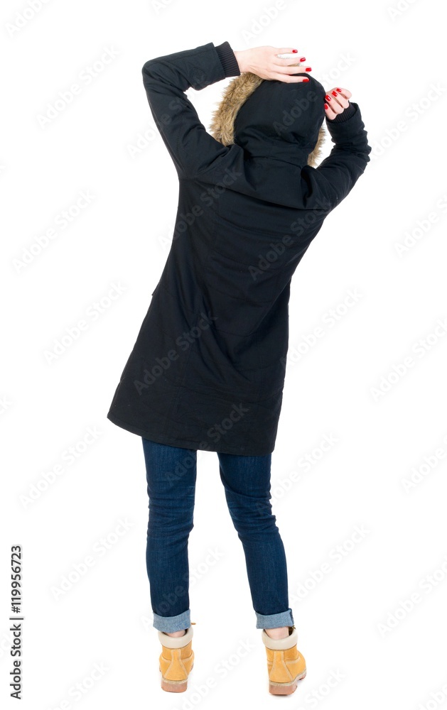 Back view woman in winter jacket Balances waving his arms. Standing ...