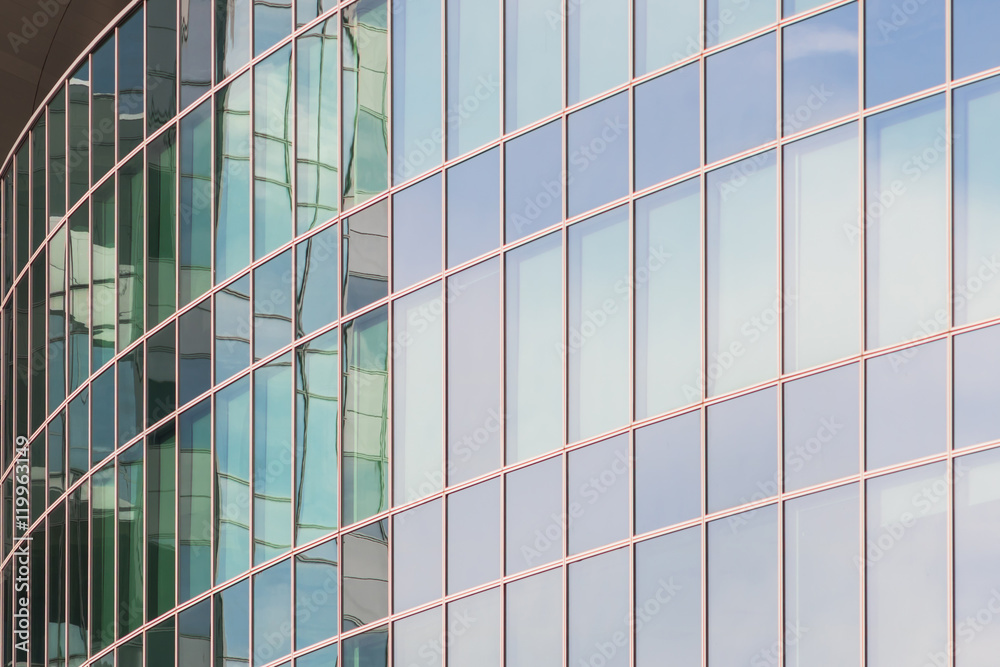 The glass facade of a skyscraper with a mirror reflection of sky ...