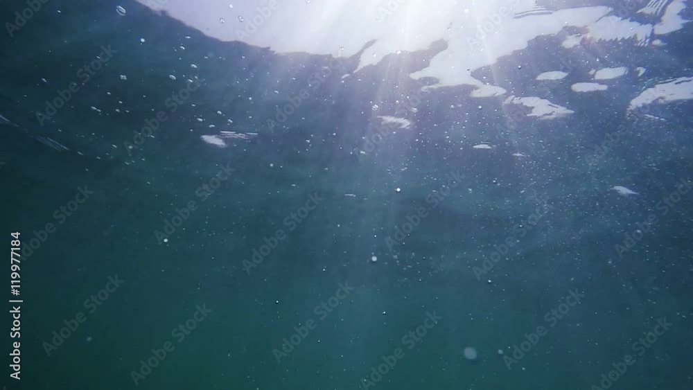 Sunlight beaming through sea water surface, underwater shot as abstract ...