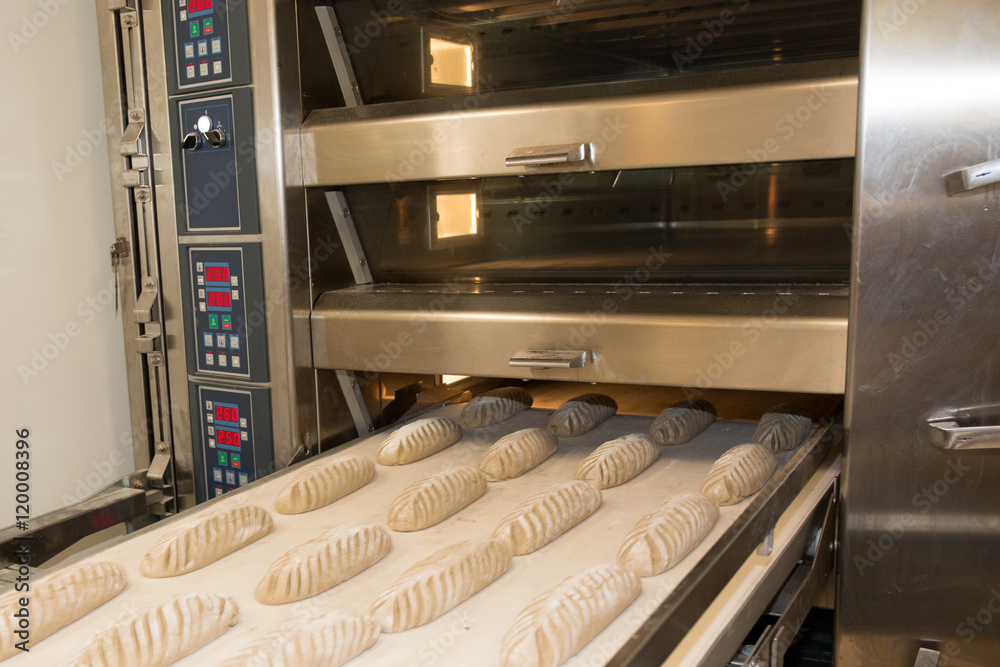 Puting fresh baked bread into the rack. Manufacturing process of ...