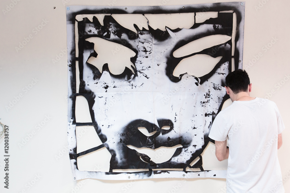 graffiti stencil street art. Two street artists paint graffiti stencil ...