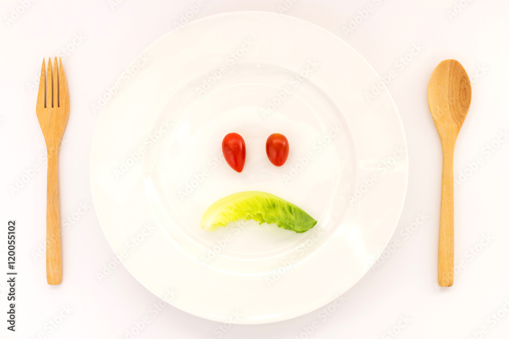 Sad face made of vegetables on the plate. Unhappy eating healthy ...