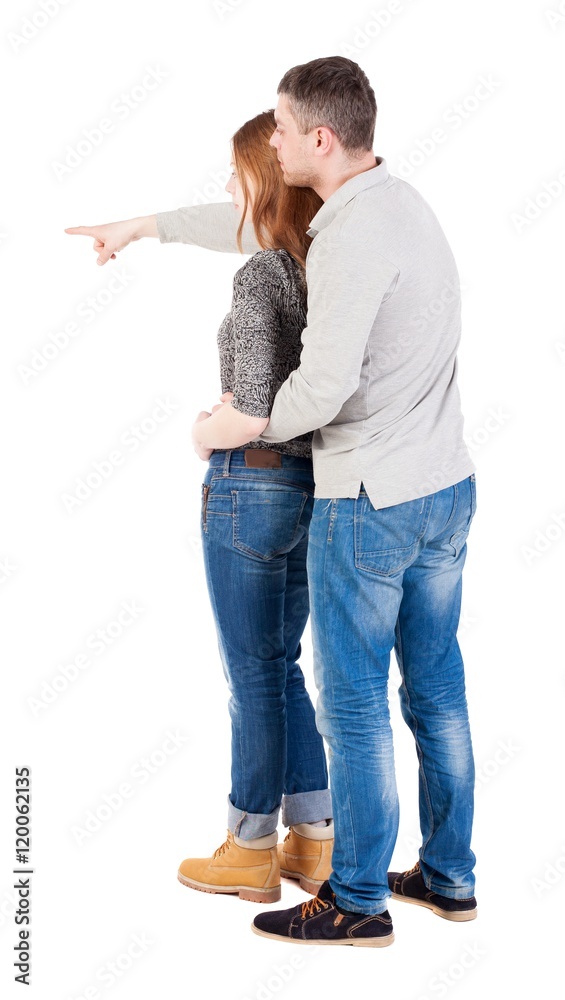 young couple pointing at wal Back view Rear view people collection ...
